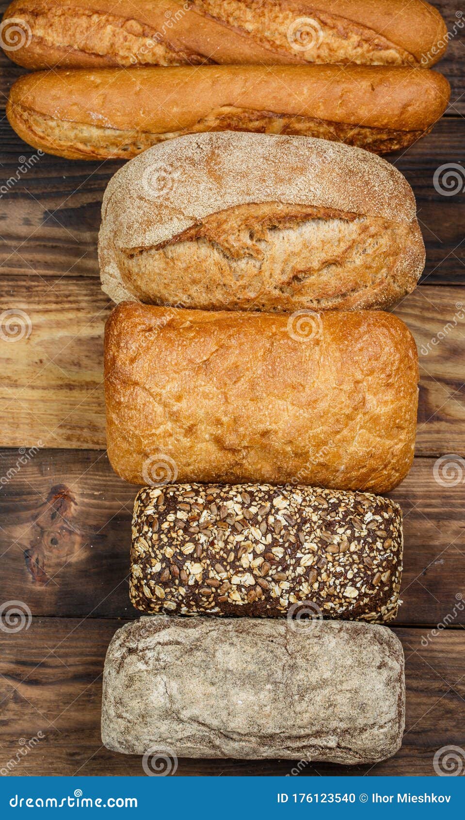 Different Loaves of Bread and Rolls with Wheat and Flour on a Wooden ...