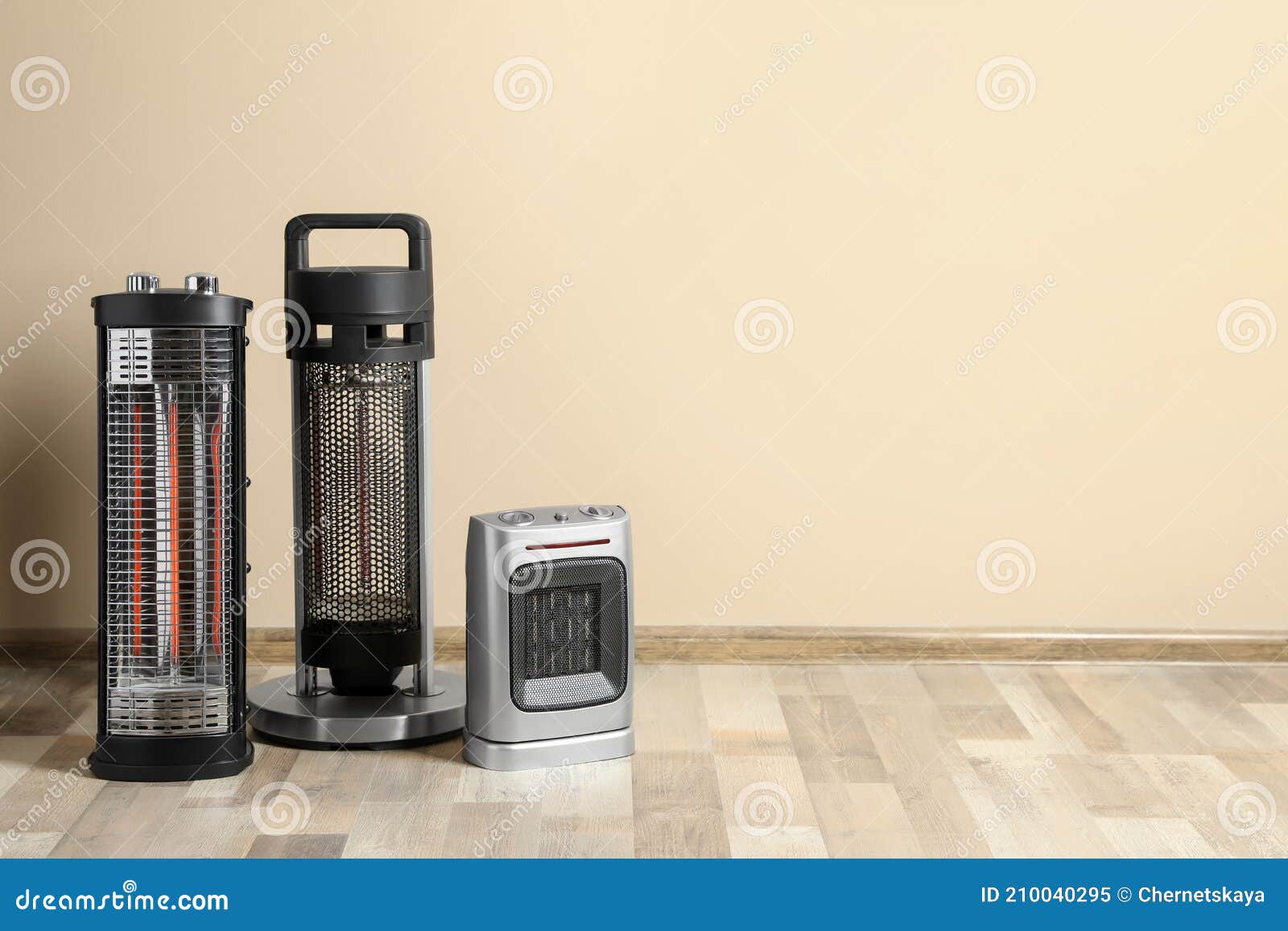 Different Modern Electric Heaters on Floor in Room, Space for Text ...