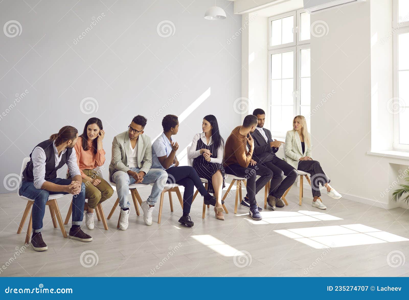 Different People Sit in Lines in Row and Communicate in Groups ...