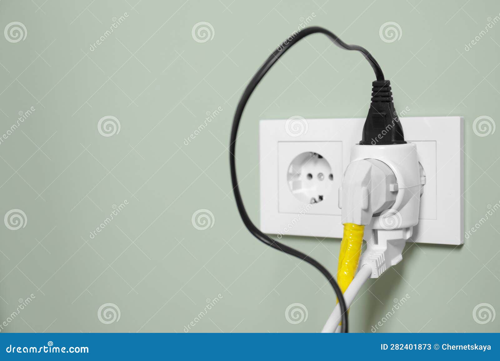 Different Power Plugs in Socket on Light Green Wall, Closeup. Space for ...