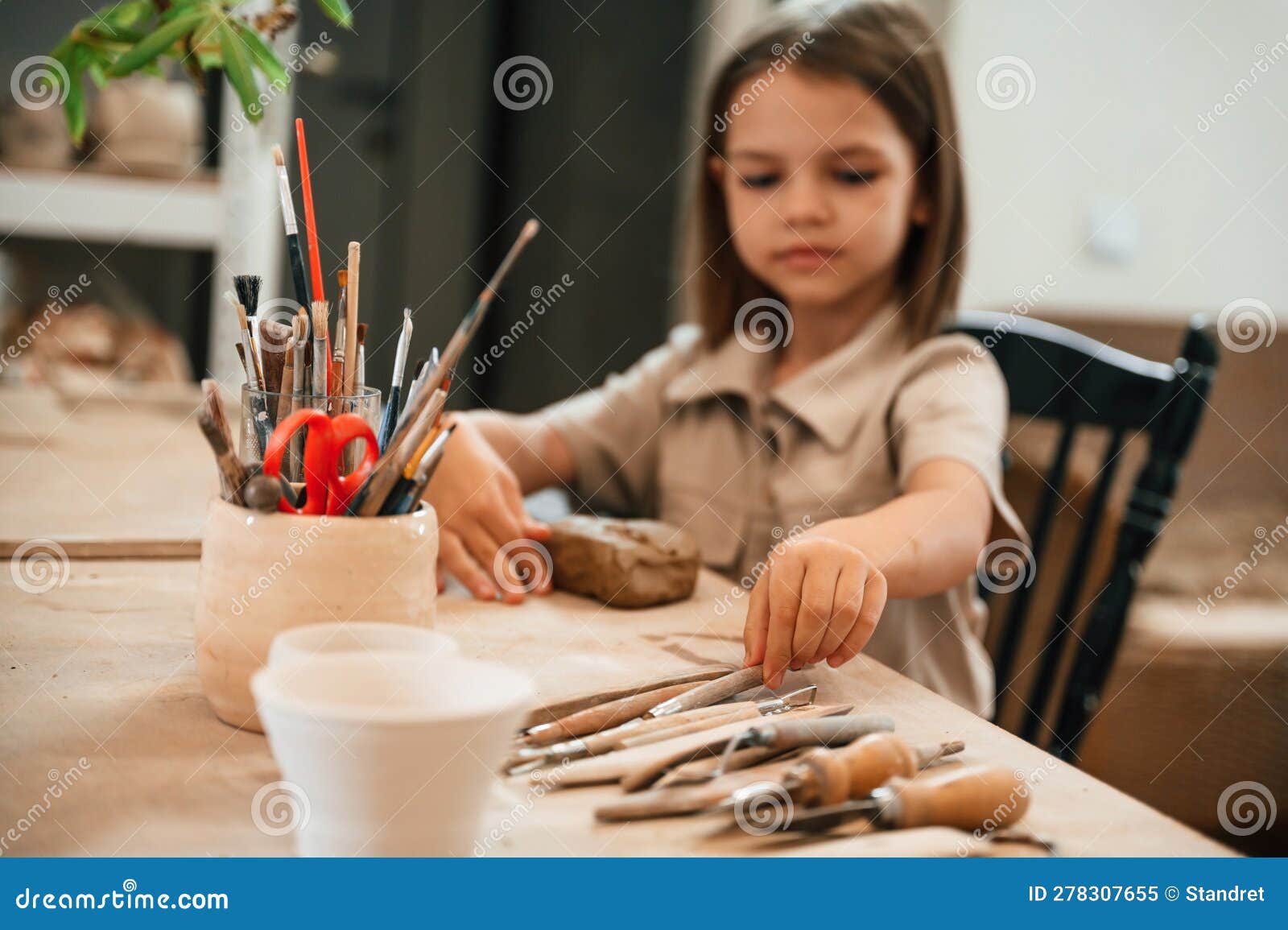 Different Tools on the Table. Little Girl is Learning How To Do Pottery ...