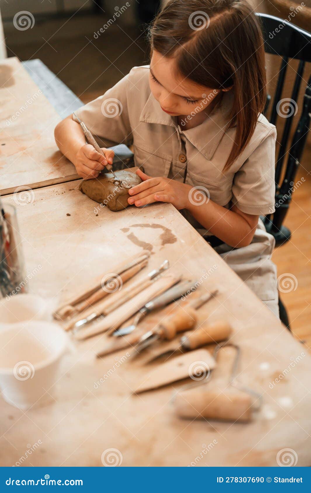 Different Tools on the Table. Little Girl is Learning How To Do Pottery ...
