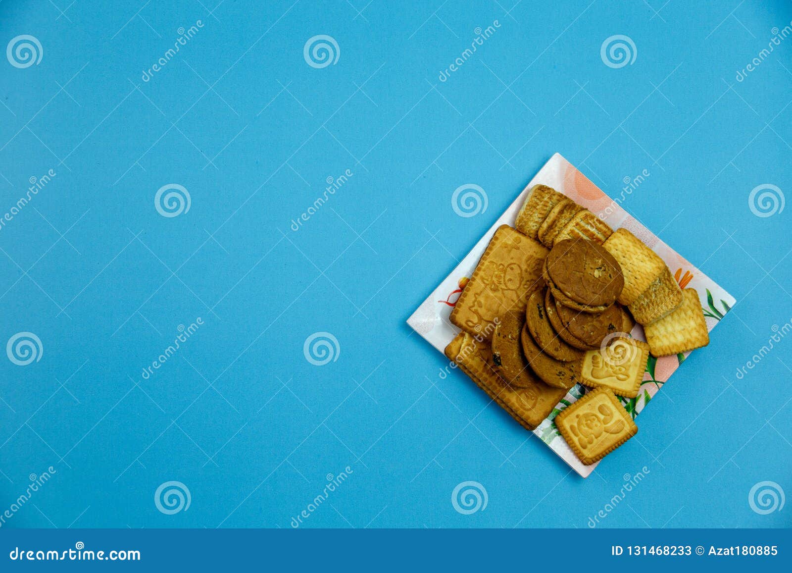 Different Types of Cookies on a Colored Square Plate on a Blue Isolated ...