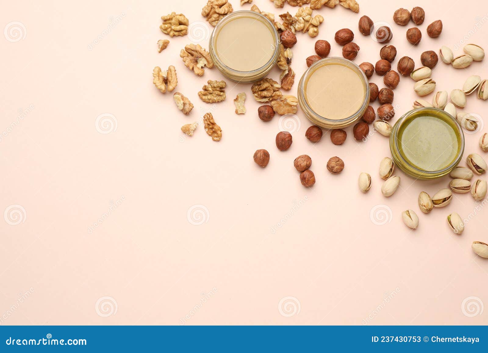 Different Types Of Delicious Nut Butters And Ingredients On Beige Background Flat Lay Space