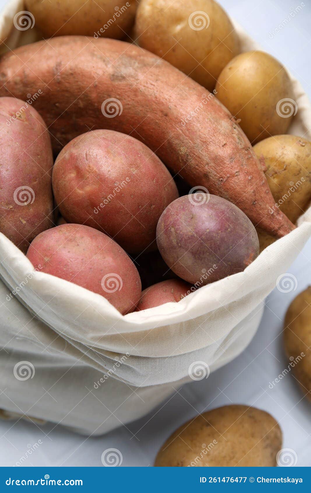 Different Types of Fresh Potatoes in Bag on White Table, Closeup Stock ...