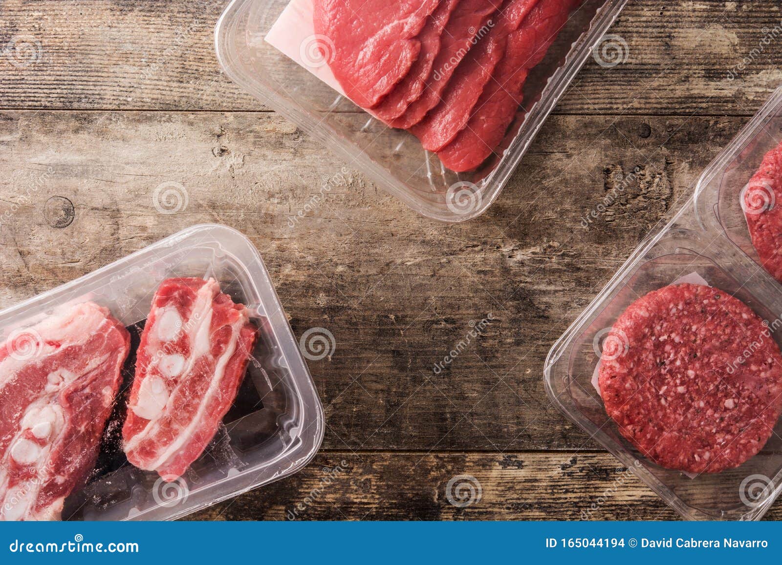 Different Types of Meat Packaged in Plastic on Wooden Table. Stock ...