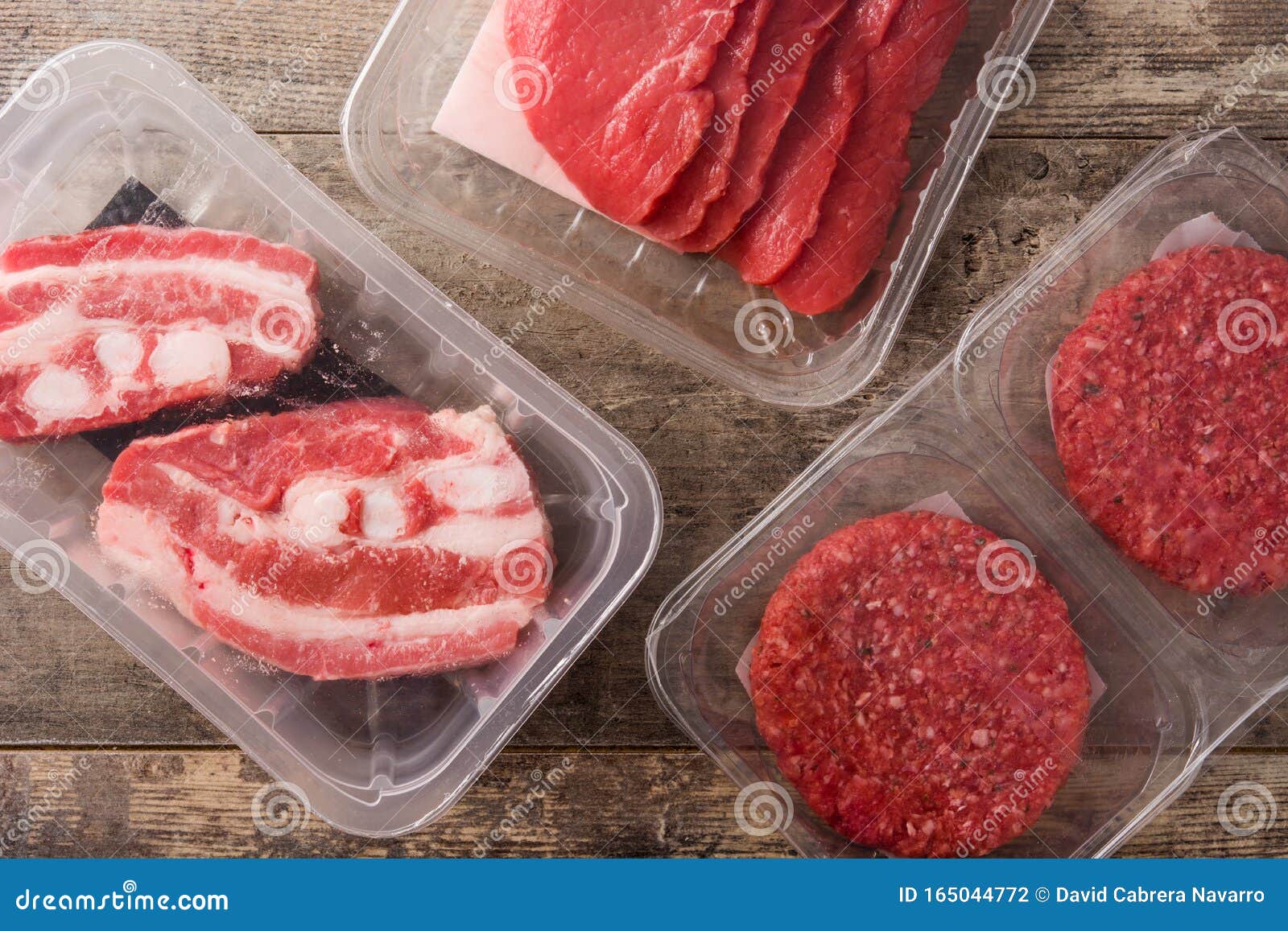Different Types of Meat Packaged in Plastic on Wooden Table. Stock ...