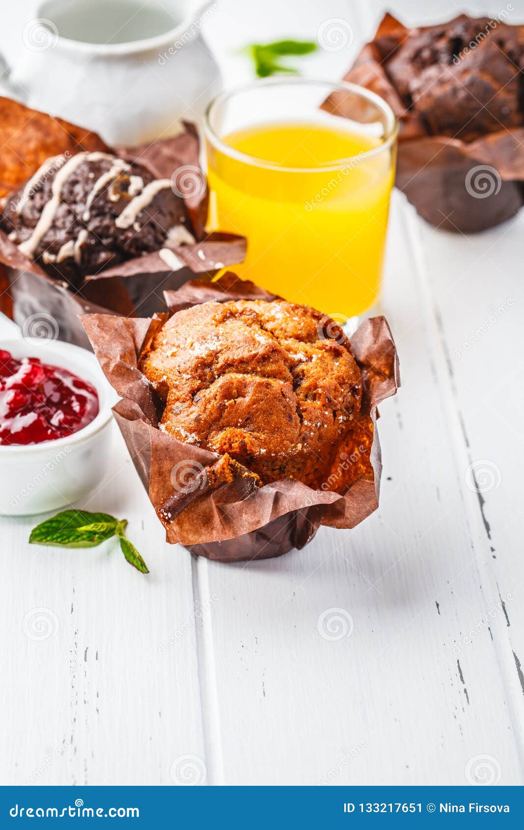 Different Types of Muffins on White Table with Juice and Milk for ...