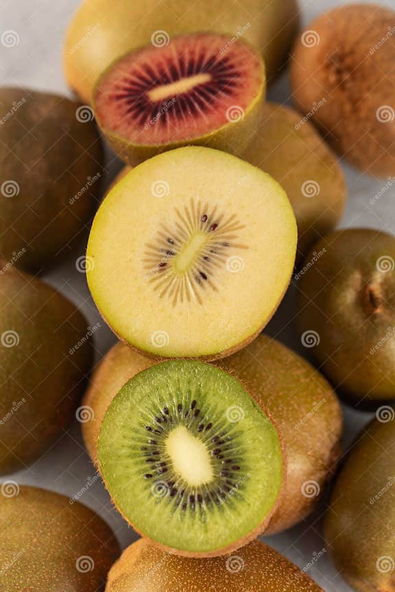 Different Varieties of Kiwi Lie in a Pile on the Table. Halves of Red ... Different Varieties of Kiwi Lie in a Pile on the Table. Halves of Red ...