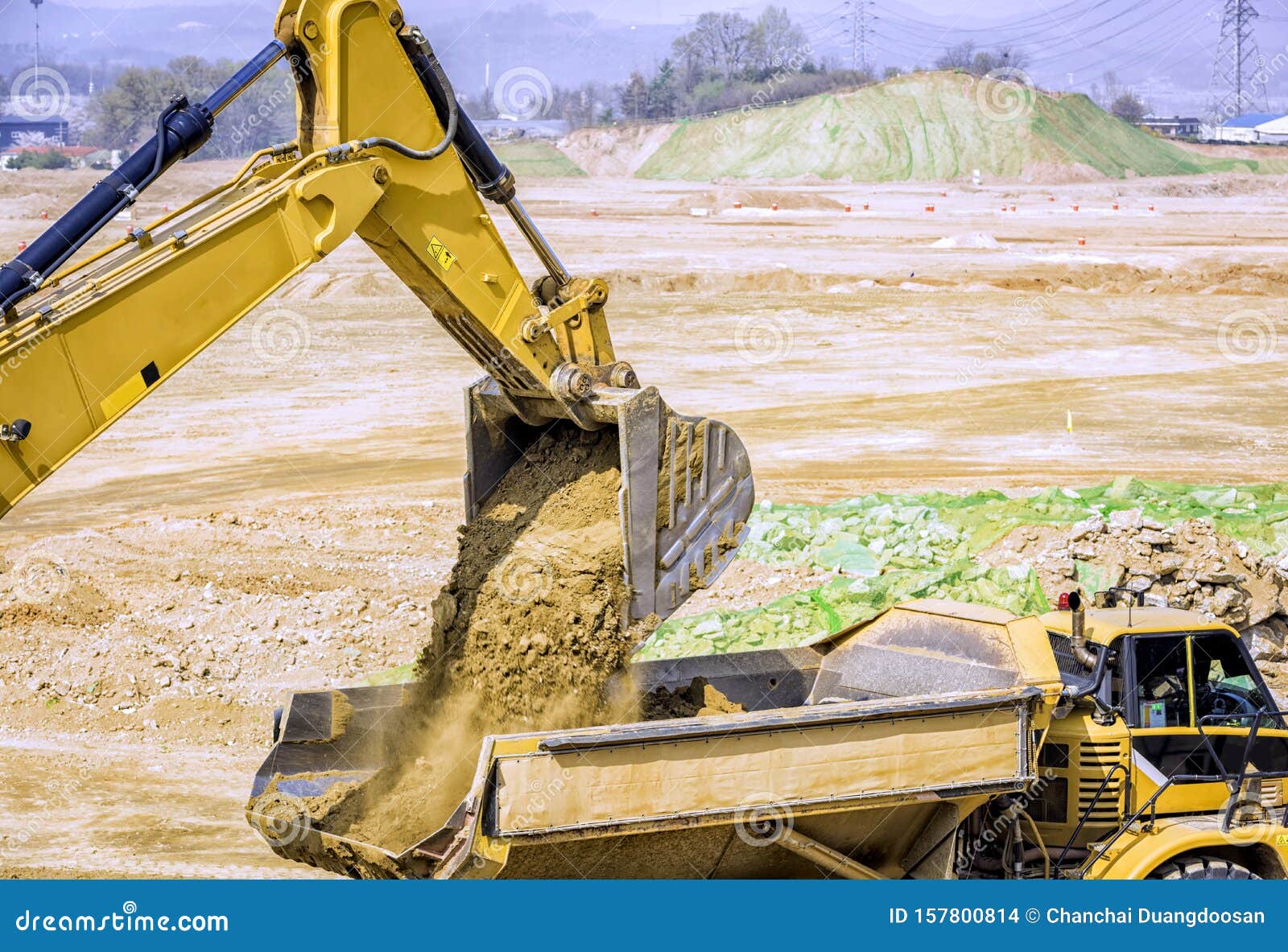 Digger Loading a Trailer on Construction Site Stock Photo - Image of ...