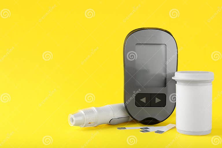 Digital Glucometer, Lancet Pen, Container and Test Strips on Yellow ...