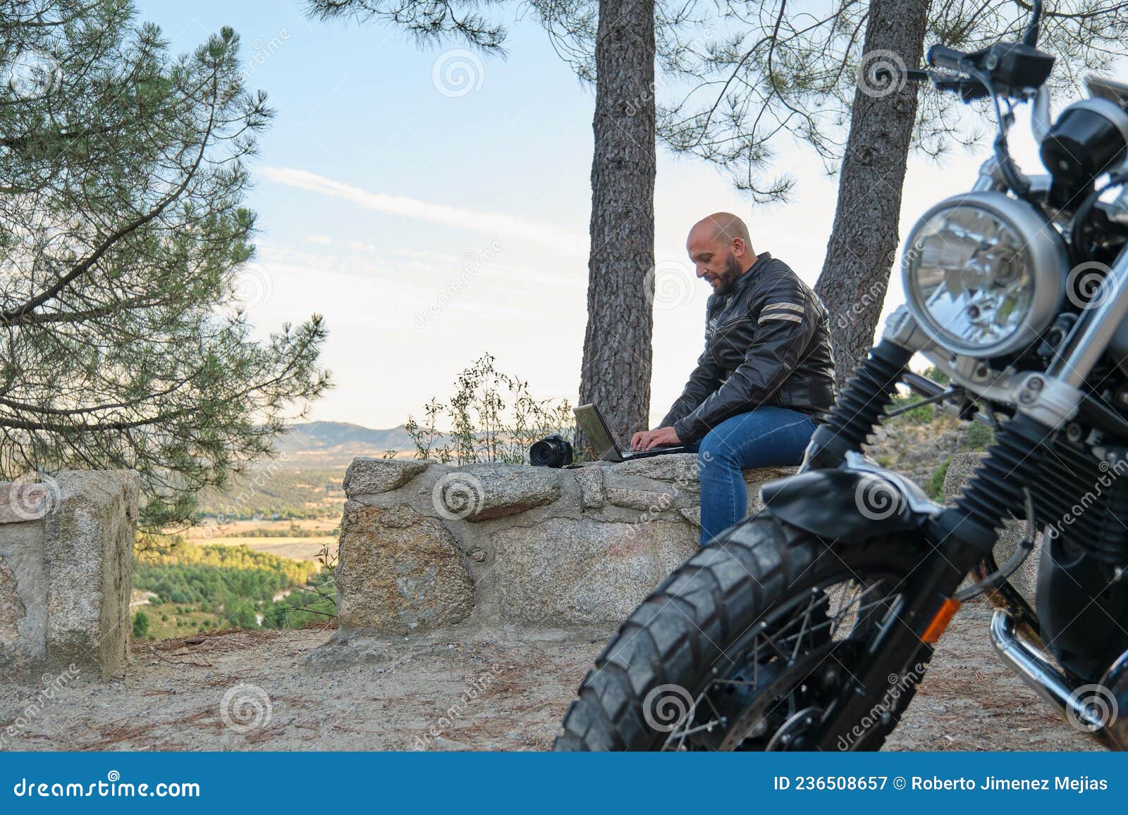 A Digital Nomana Man Working on His Laptop while Riding a Motorcycle ...