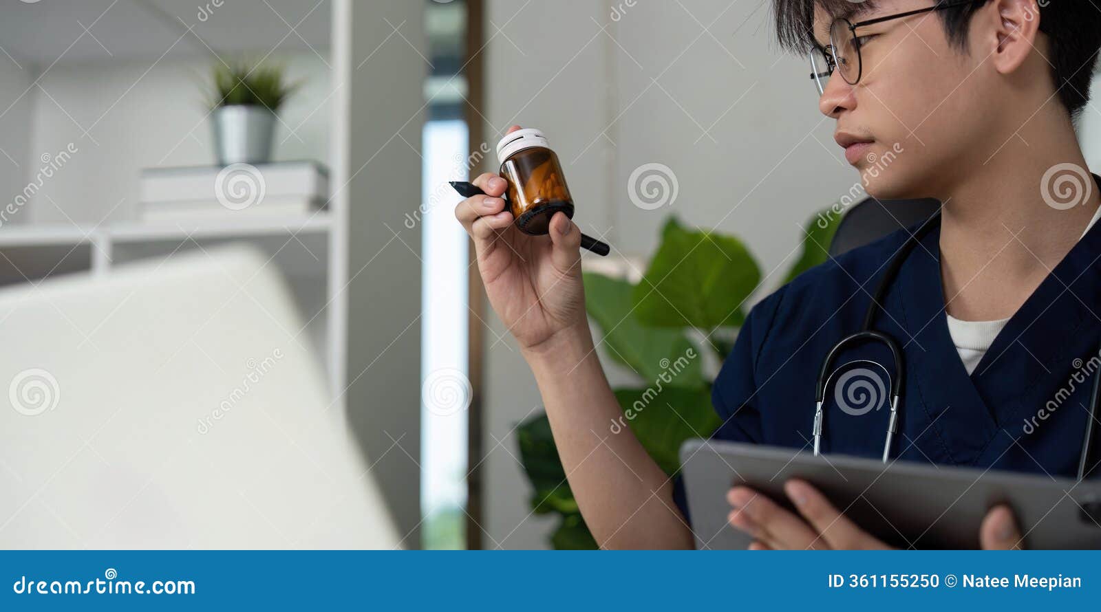 Medical Student Examining Medication while Taking Notes in a ...