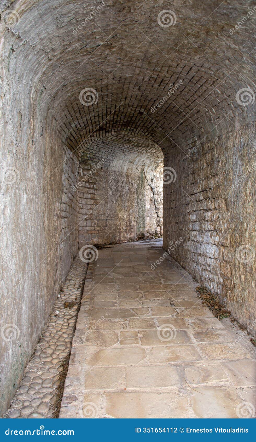 Dimly Lit Brick Tunnel with Stone Pathway Stock Photo - Image of ...