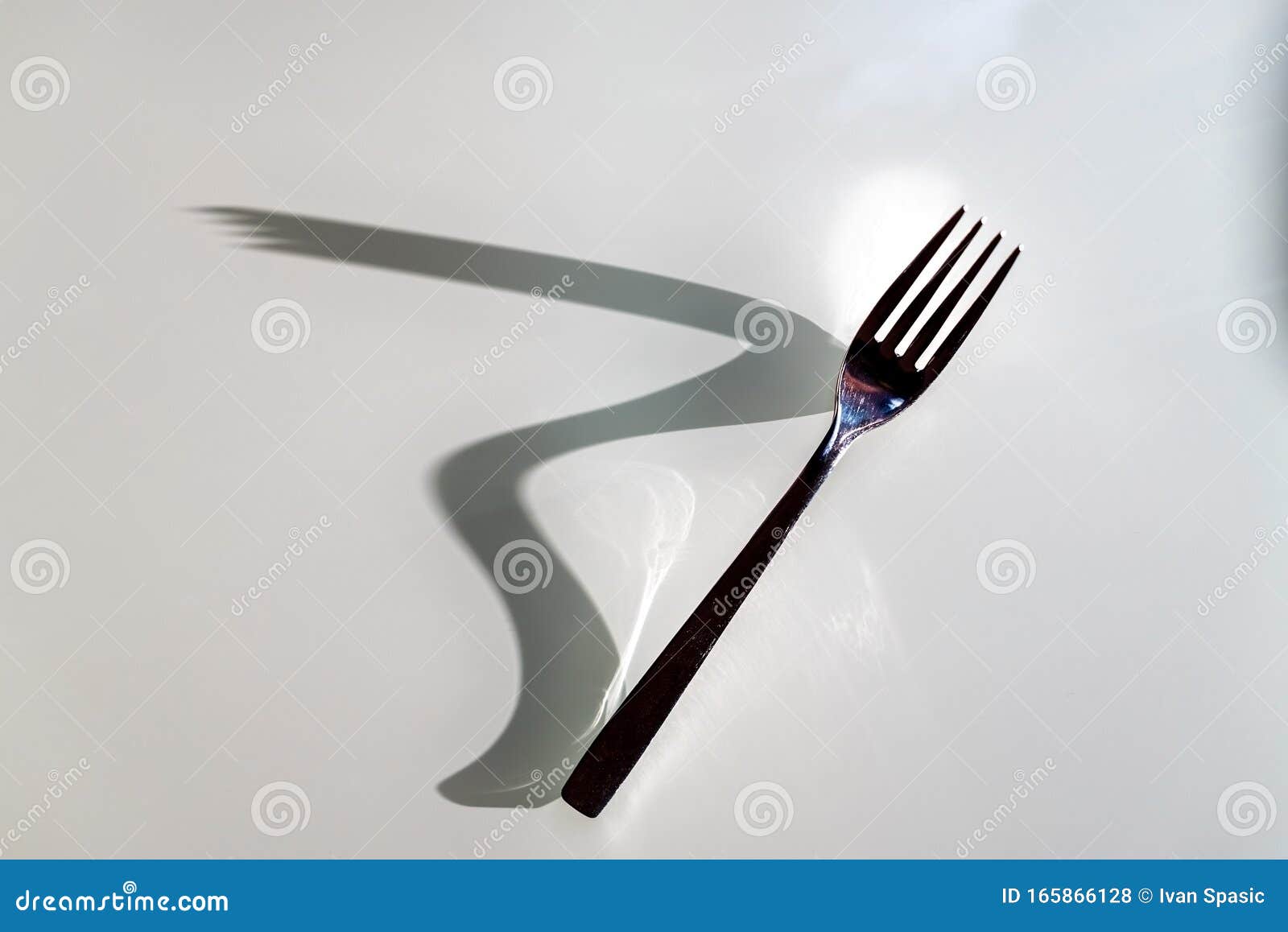 Fork Throws Large Elongate Shadow on Glass Table Stock Photo - Image of ...