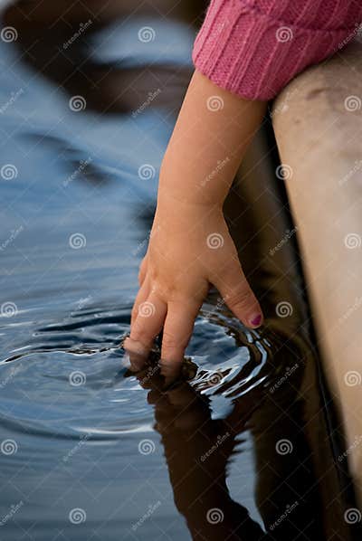 Dipping fingers into pond stock photo. Image of child - 4057016