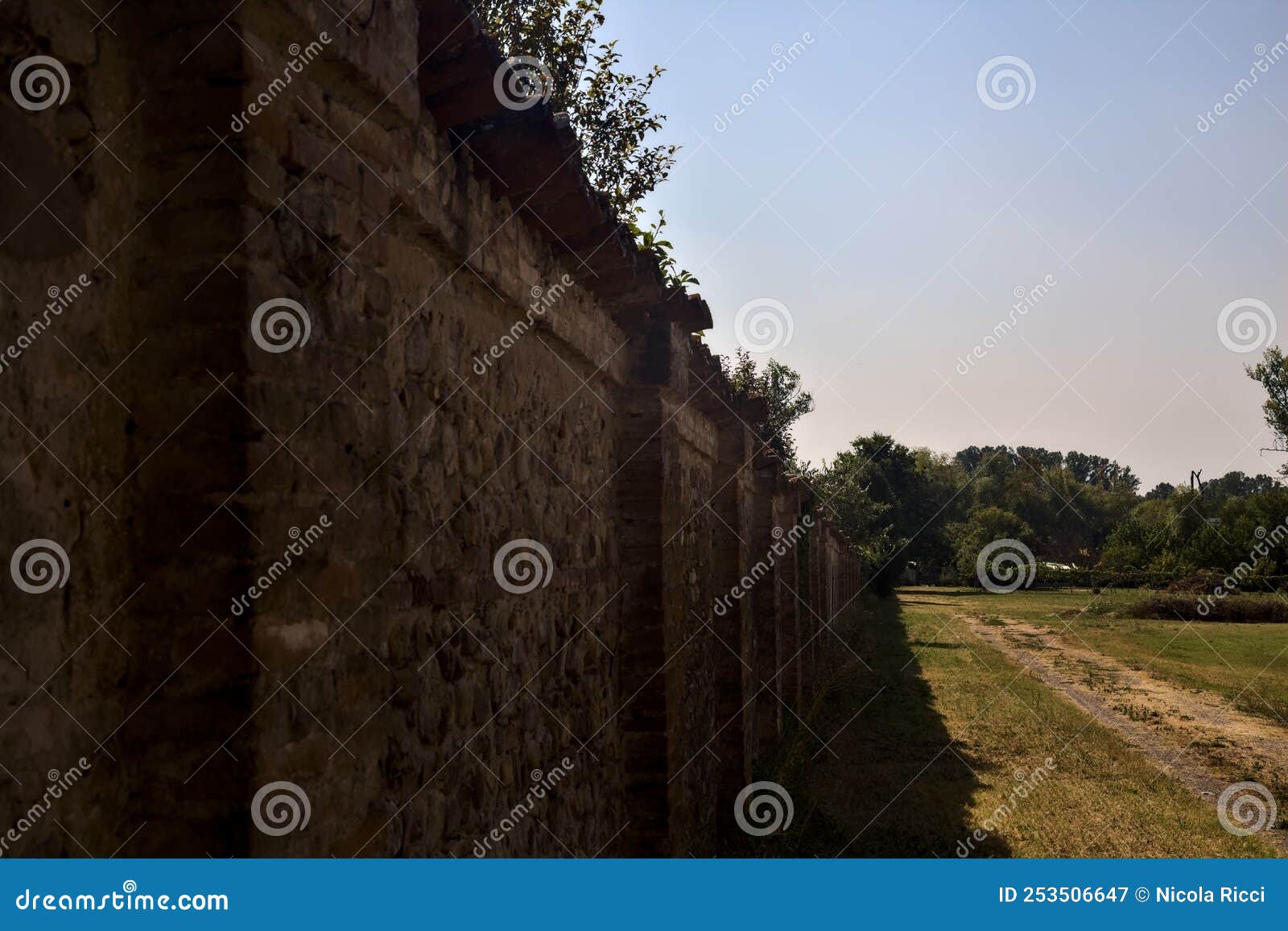 Dirt Path Next To a Boundary Wall in a Park Stock Image - Image of blue ...