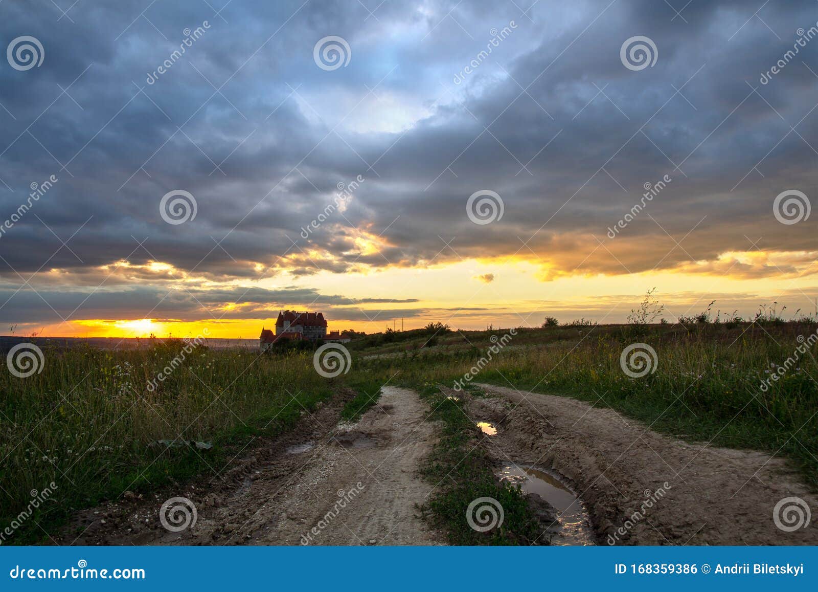 Dirt Road among Dark Fields at Sunset with Dramatic Cloudscape Stock ...