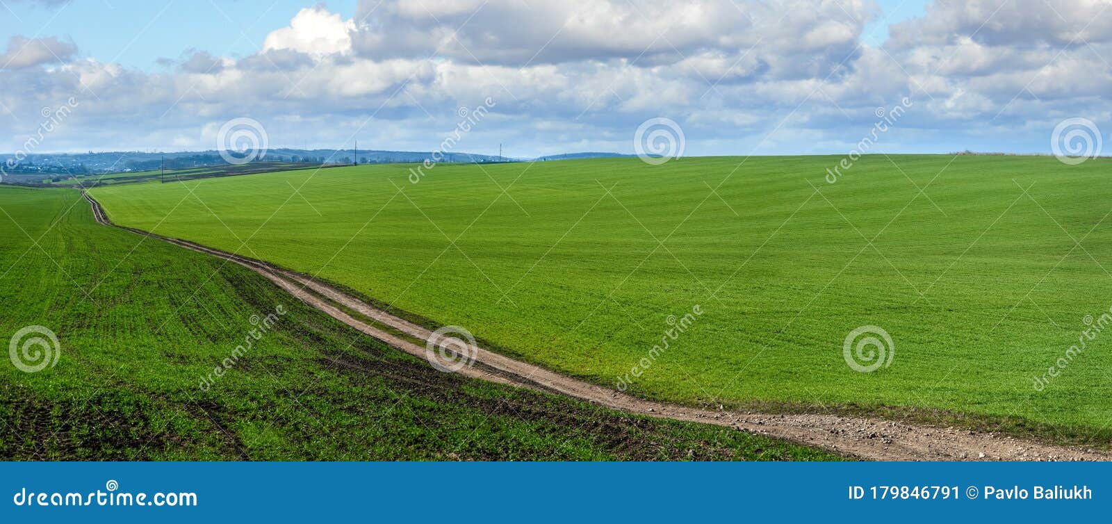 Dirt Road through a Fields in Hilly Terrain in Spring with Cloudy Skies ...