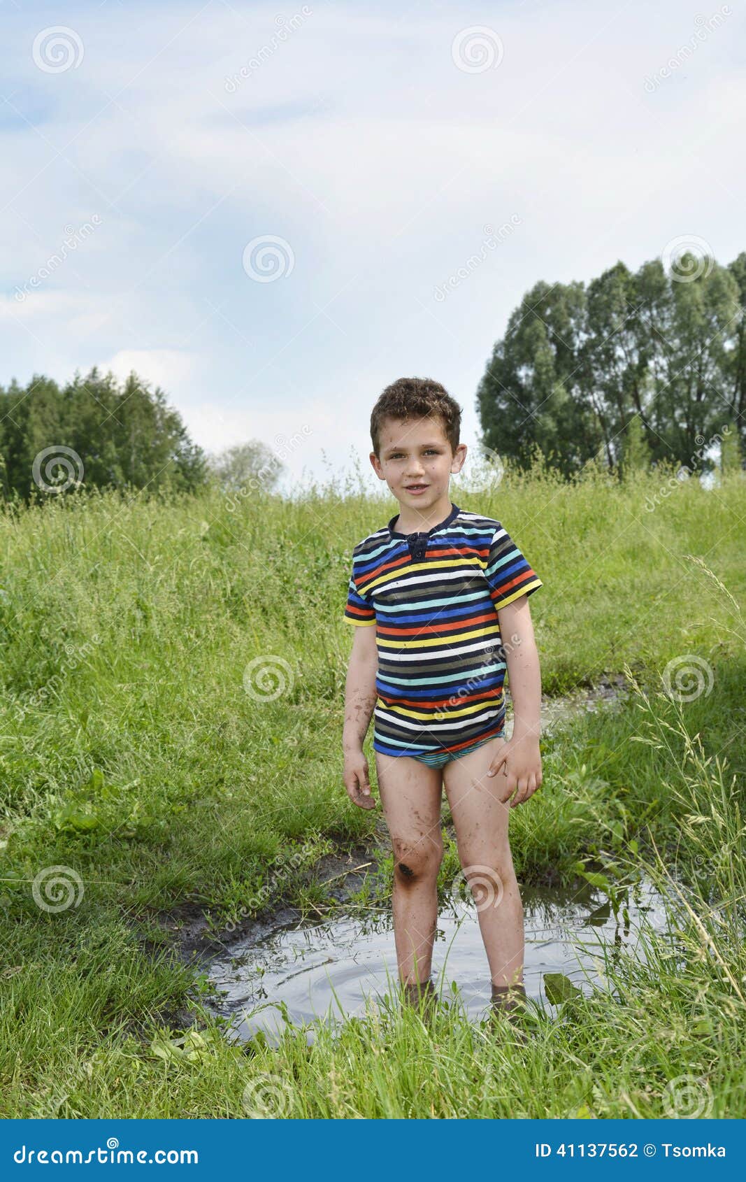 Dirty Rural Boy Stands Barefoot in a Puddle. Stock Photo - Image of ...