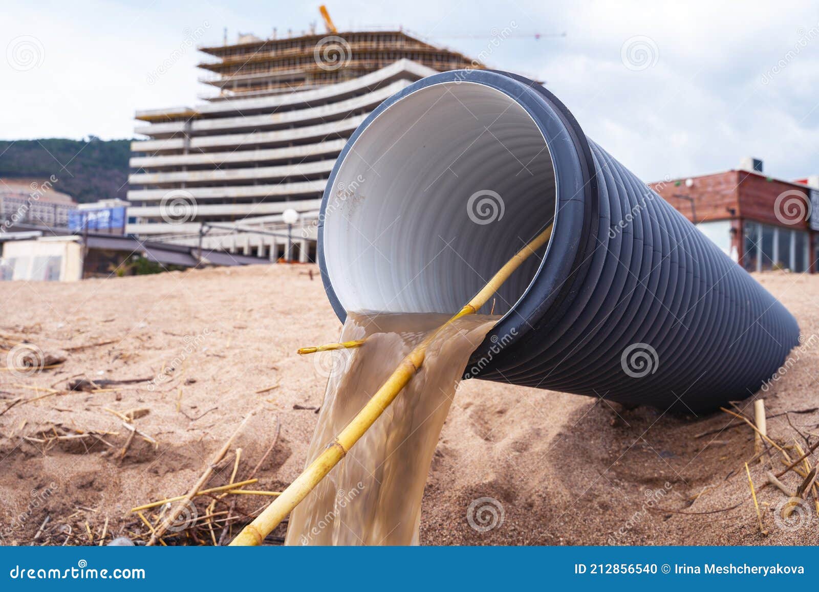 Dirty Water Pours from Sewer Pipe, Dried Reed Stem Sticks Out from ...