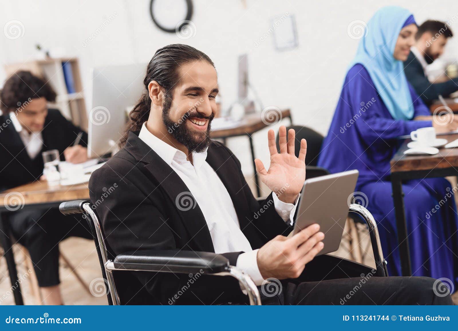 Disabled Arab Man in Wheelchair Working in Office. Man is Talking on ...