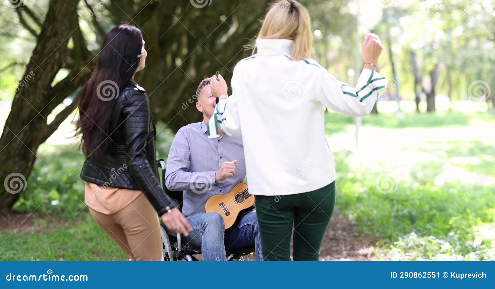 Disabled Man Plays Guitar in Park Two Women Dance Stock Video - Video ...