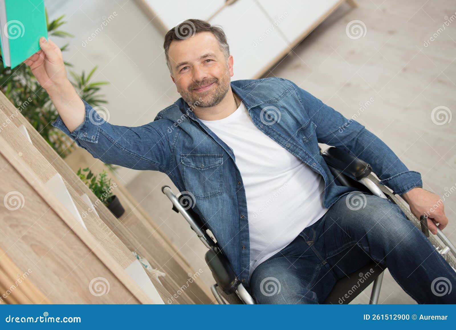 Disabled Man Reaching Up for Book from Shelf Stock Photo - Image of ...