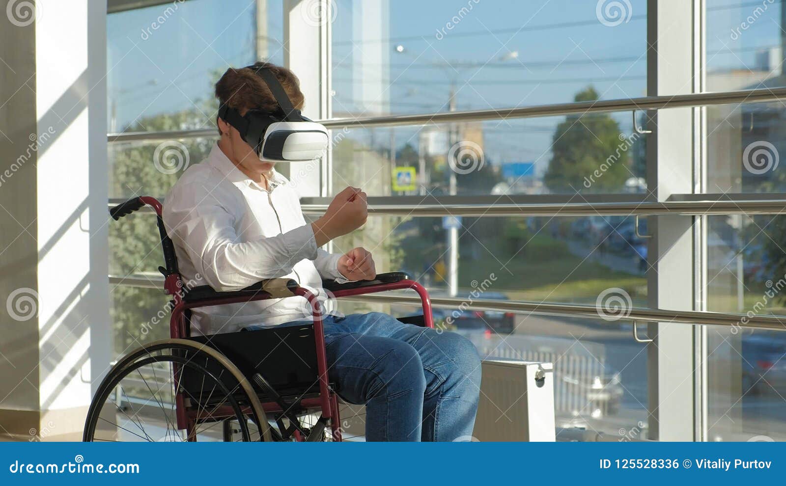 Disabled Man on a Wheelchair at a Window Uses a Helmet of Virtual ...