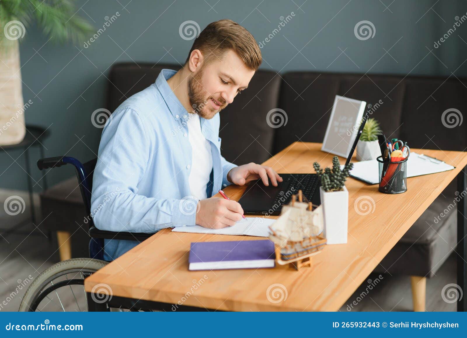 Disabled Person in the Wheelchair Works in the Office at the Computer ...