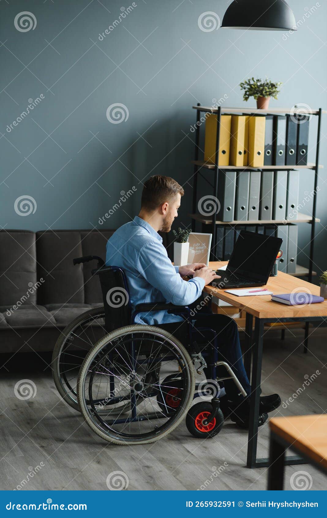 Disabled Person in the Wheelchair Works in the Office at the Computer ...