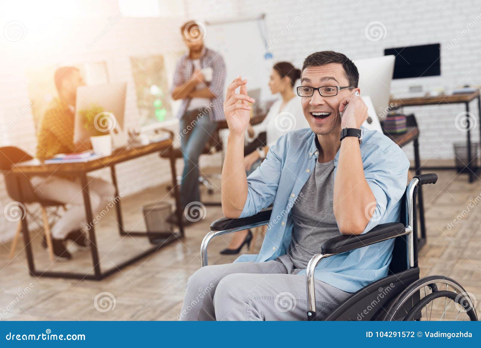 Disabled Person In The Wheelchair Works In The Office He Talks On