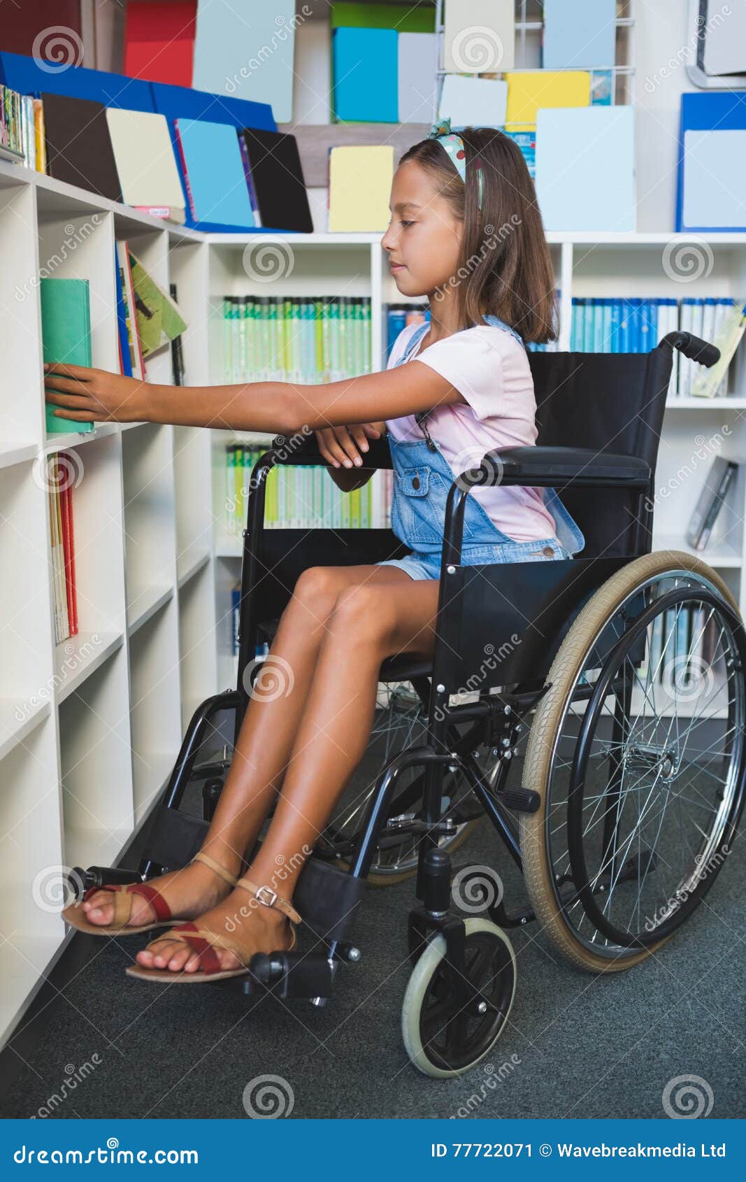Disabled School Girl Selecting a Book from Bookshelf in Library Stock ... Disabled School Girl Selecting a Book from Bookshelf in Library Stock ...