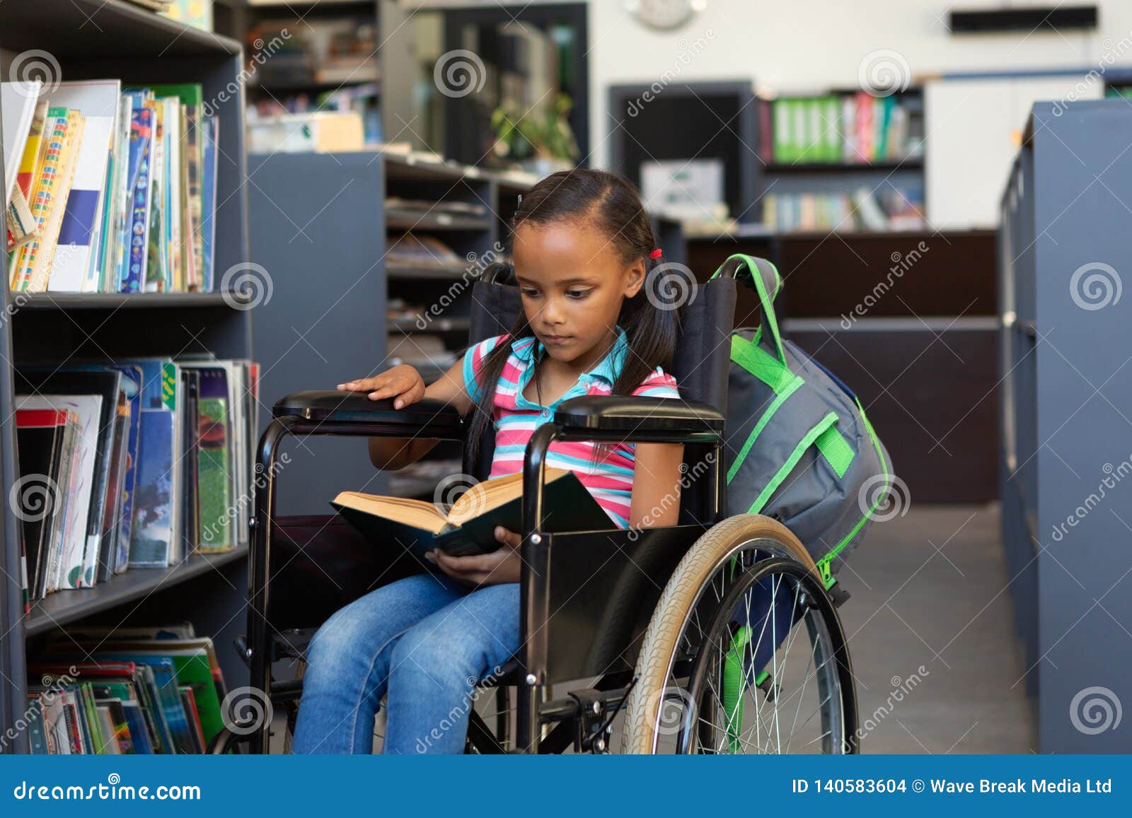 Disabled Schoolgirl Reading a Book in the Library Stock Photo - Image ...