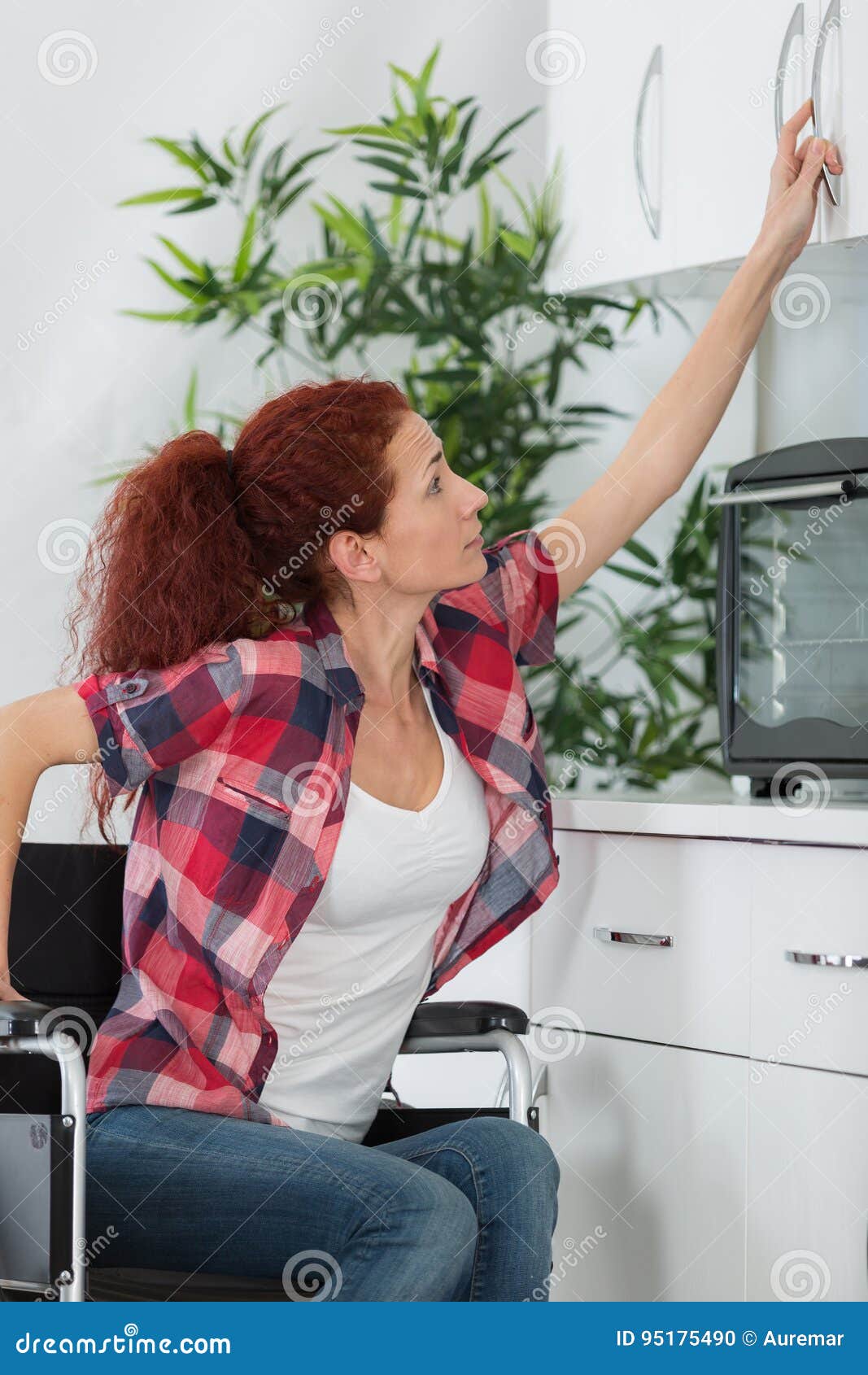 Disabled Woman Struggling To Open Cupboard in Kitchen Stock Photo ...
