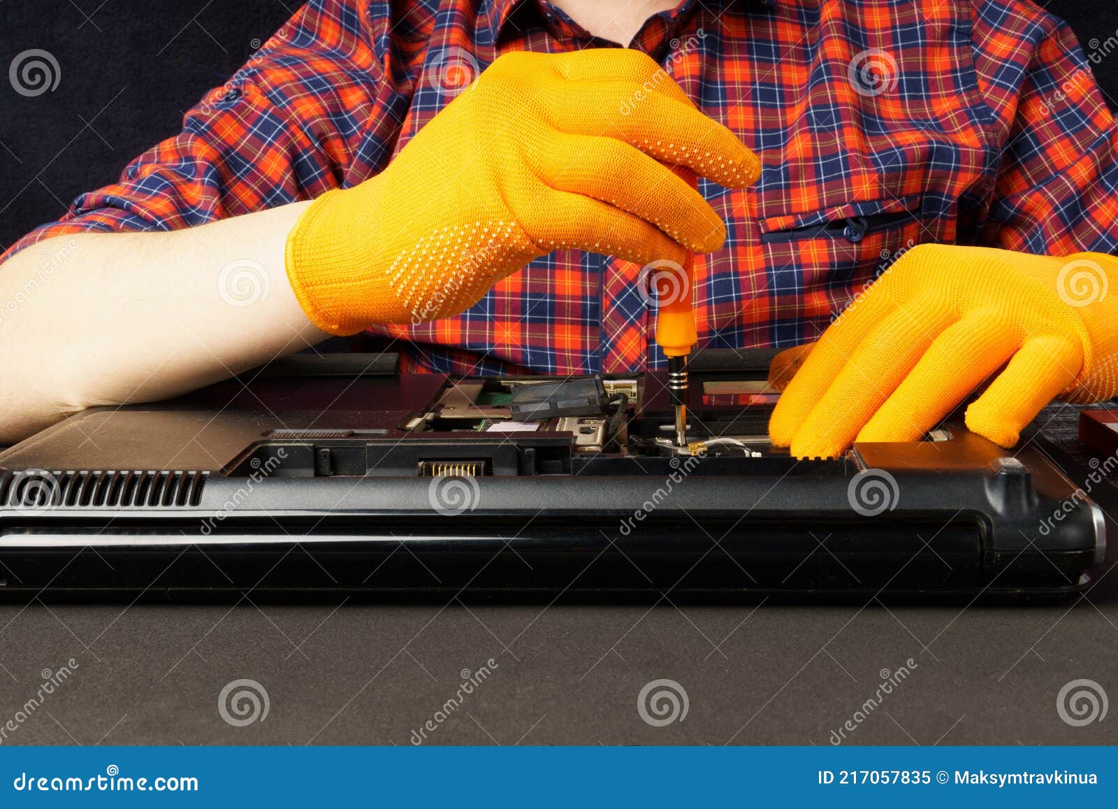 Disassembling a Laptop in a Workshop. the Wizard Unscrews the Laptop ...
