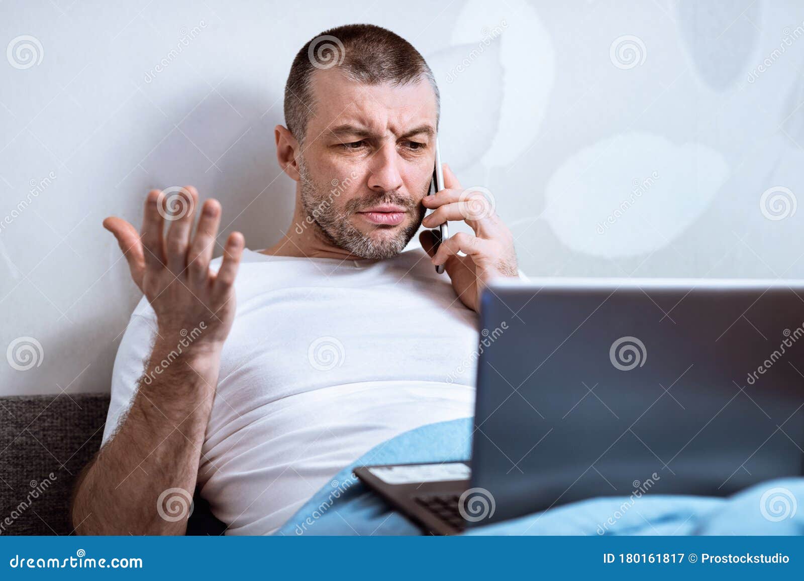 Discontented Man Calling Customer Support Sitting in Bed at Home Stock ...