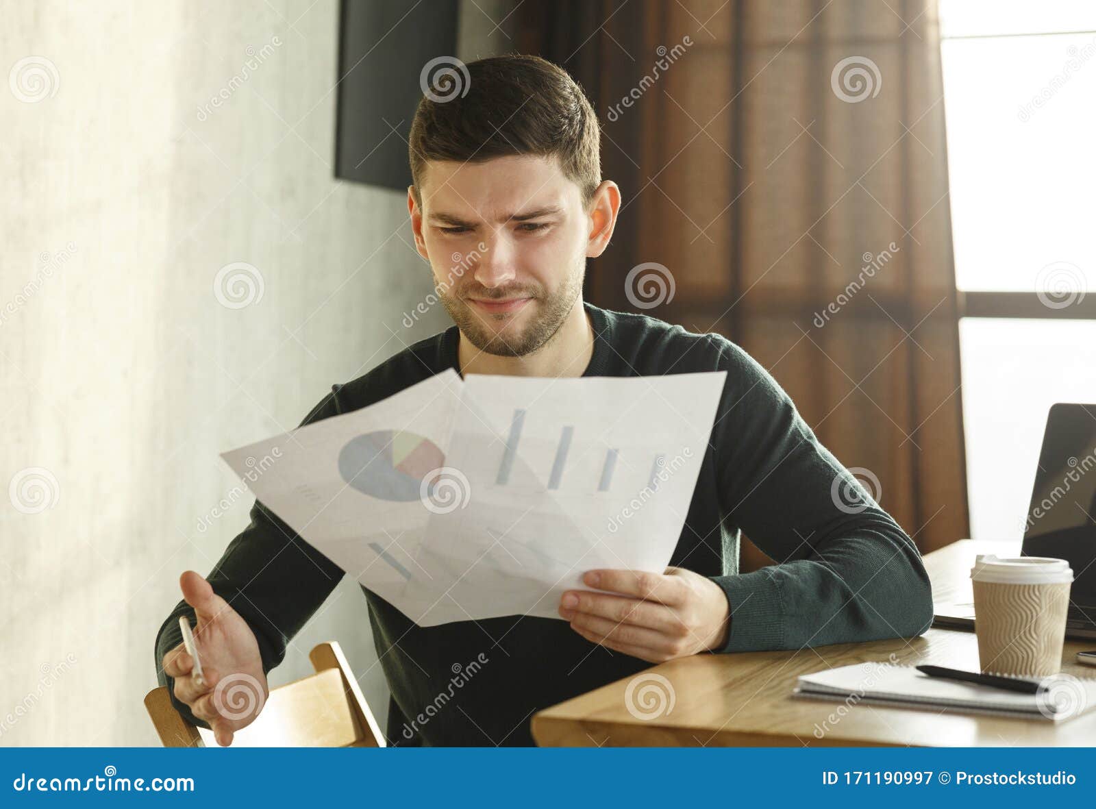 Discontented Office Worker Looking at Documents Sitting in Modern ...