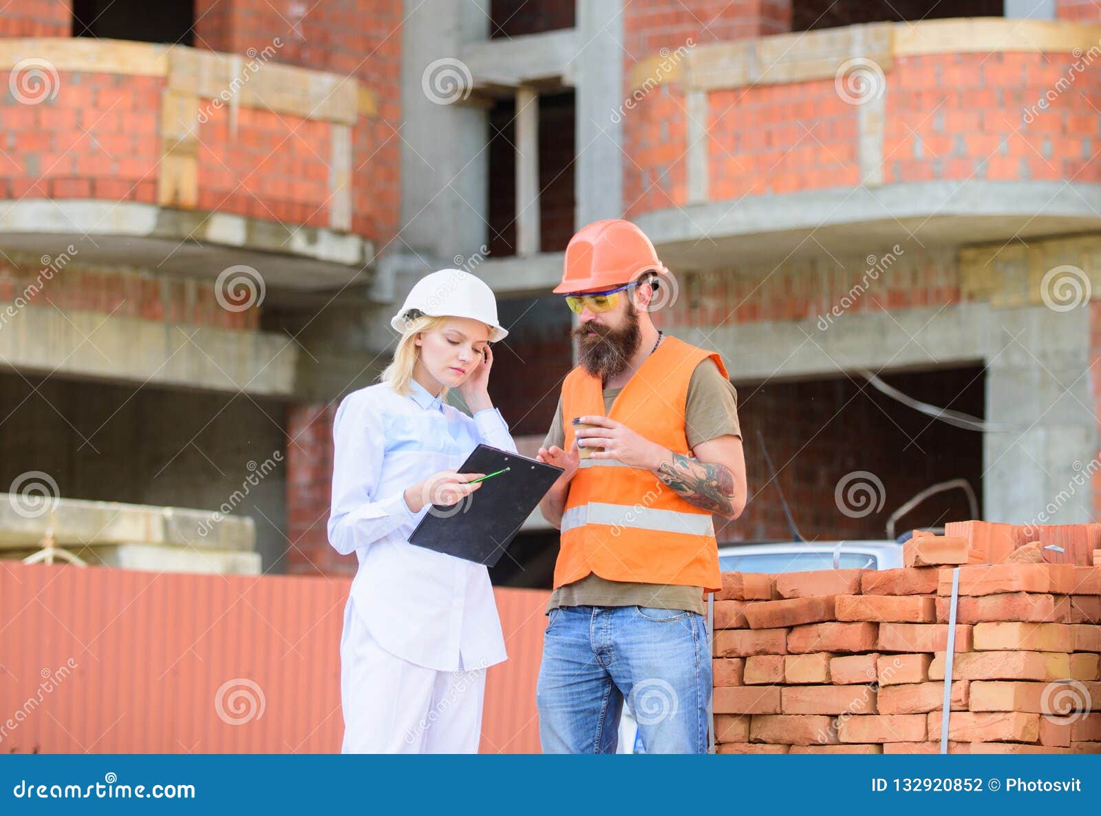 Discussing Plan. Woman Engineer and Builder Communicate at Construction ...
