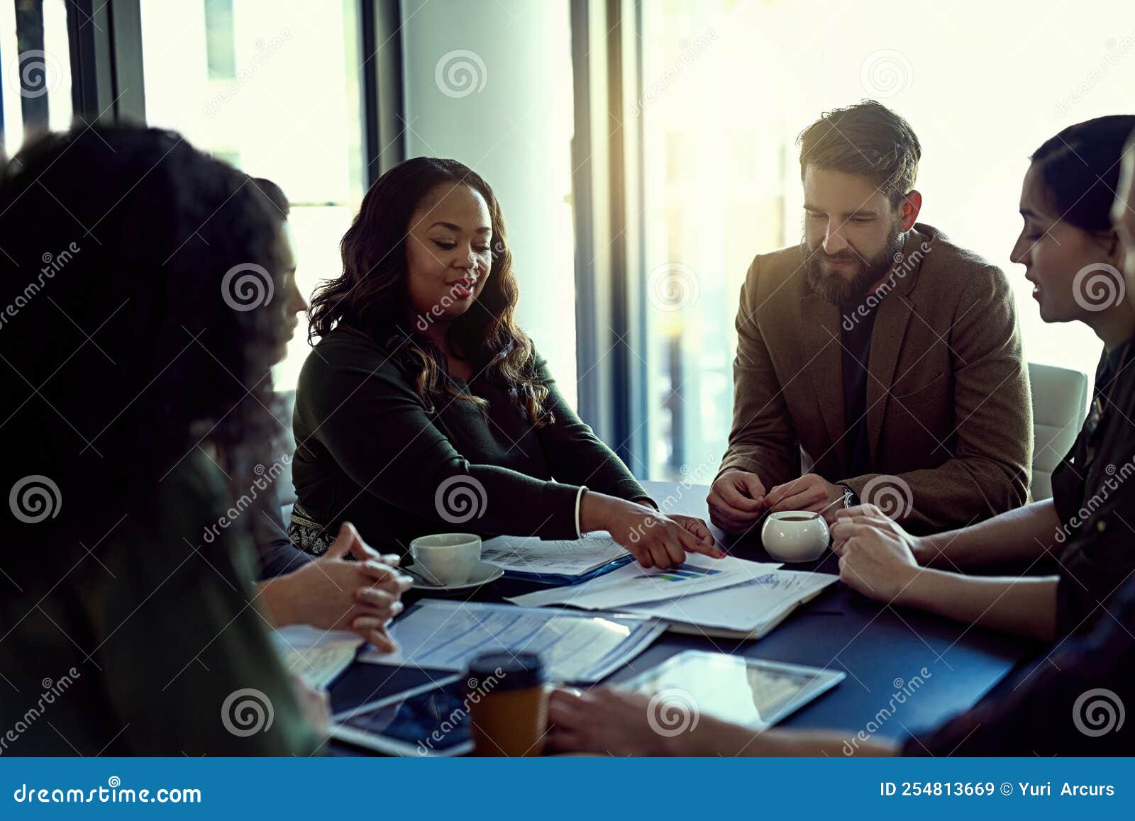 Discussing the Statistics. a Group of Businesspeople Meeting in the ...