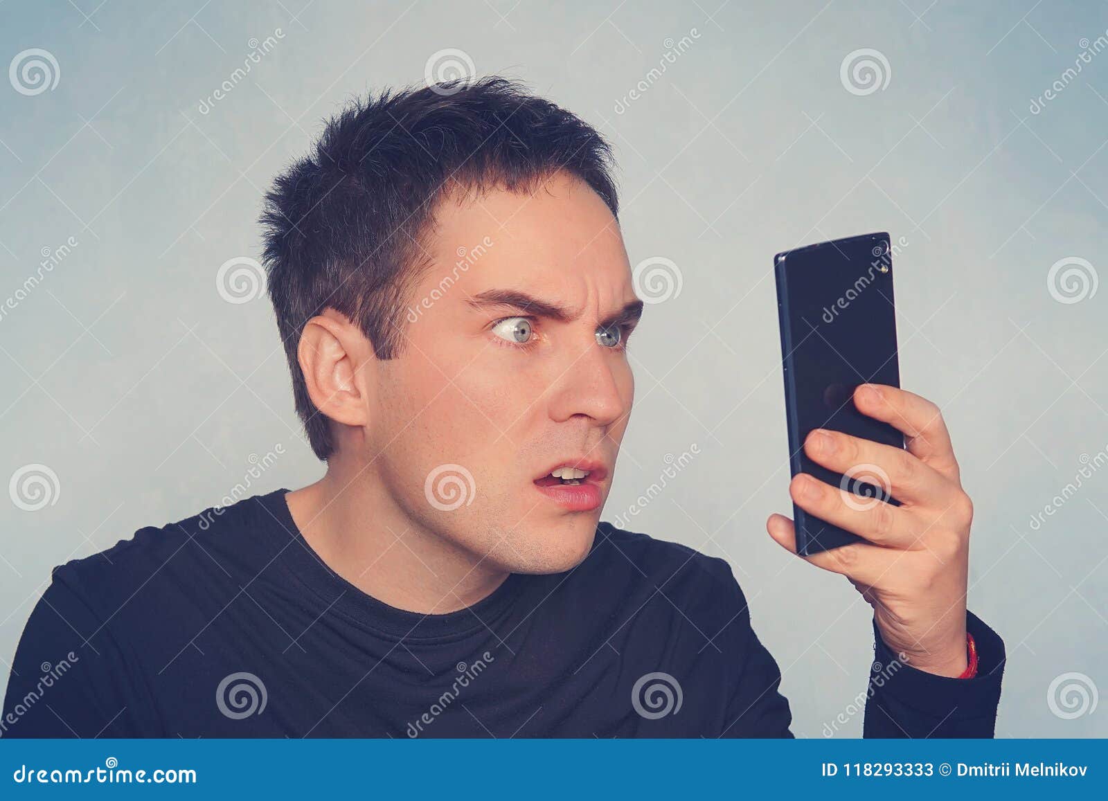 Disgusted Man Reading A Text Message Guy Looks At The Smartphone