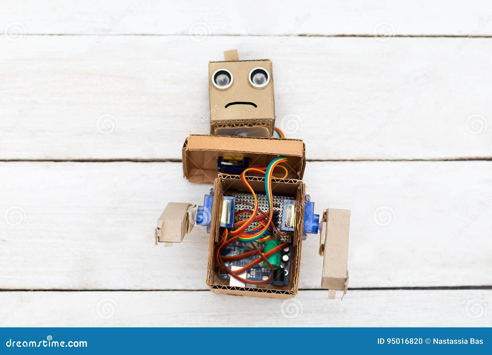 Dismantled Robot with Hands on White Wooden Background. Flat Lay Stock ...