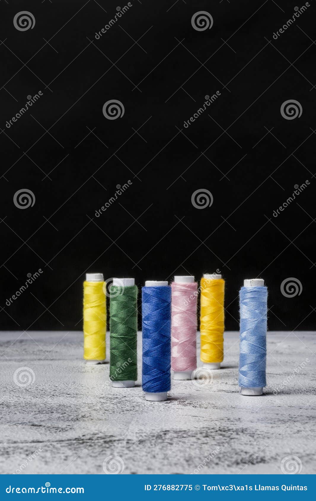 A Display of Multi Colored Thread Spools Arranged Vertically Stock ...
