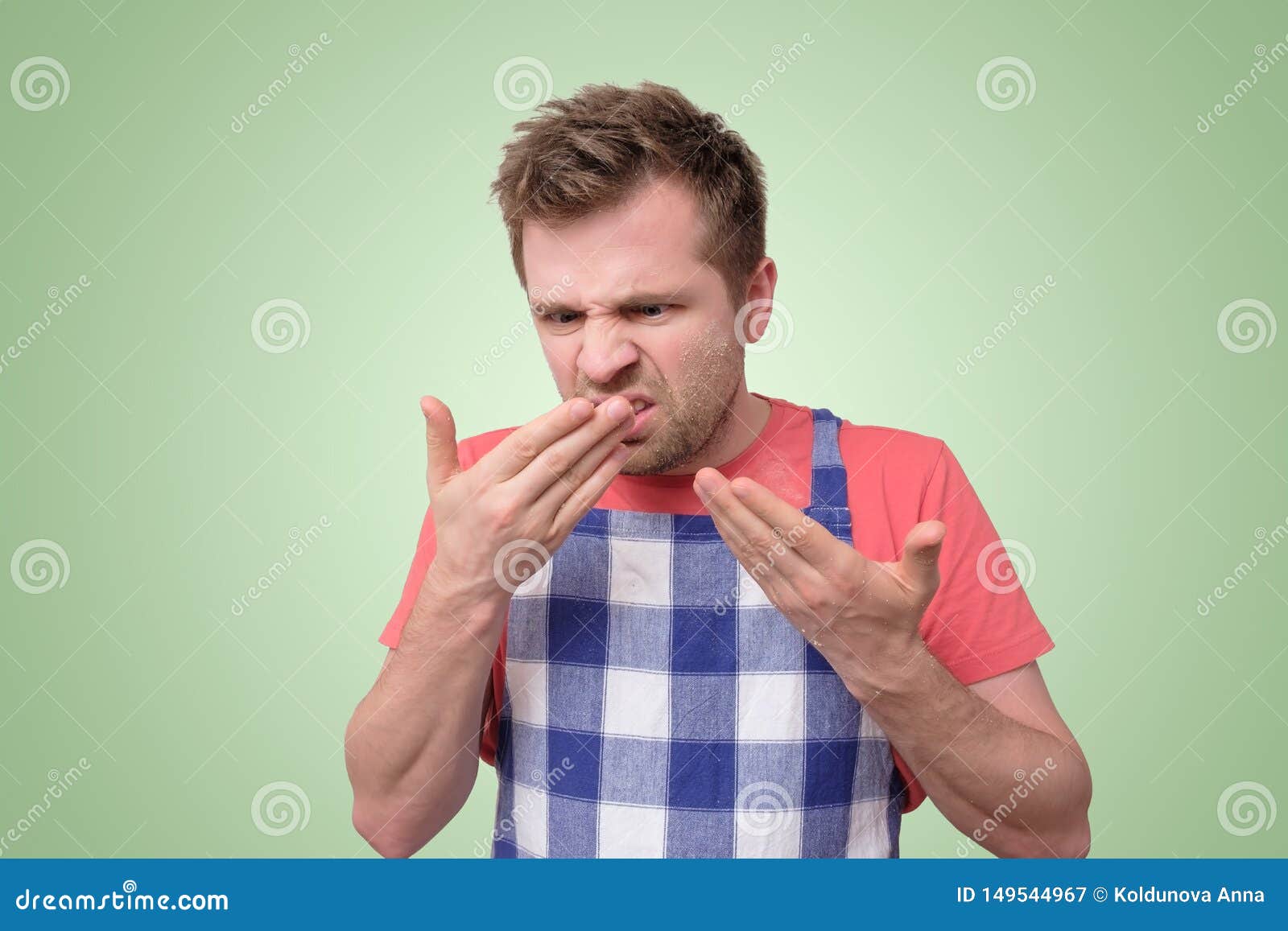 Displeased Young Man in Apron Sniffing His Hands. Stock Image - Image ... Displeased Young Man in Apron Sniffing His Hands. Stock Image - Image ...