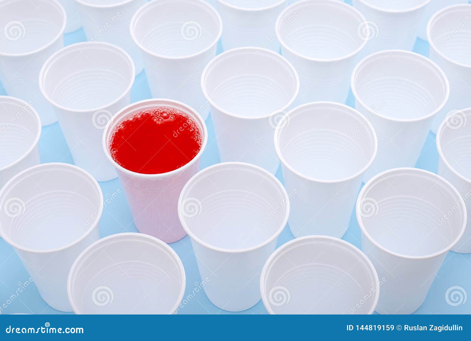 Disposable Plastic White Empty Cups on and One Glass Filled with Red ...