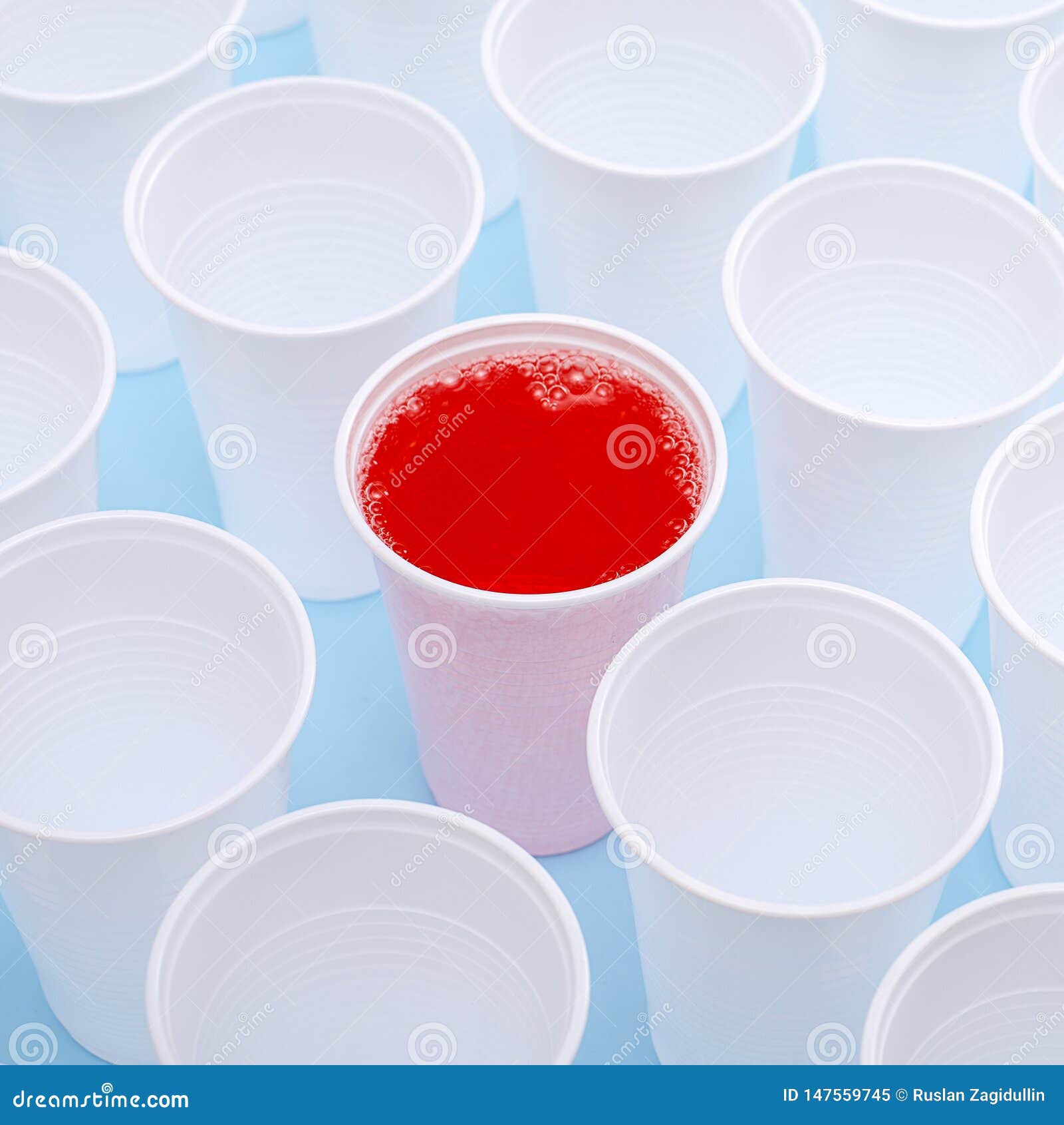 Disposable Plastic White Empty Cups on and One Glass Filled with Red ...