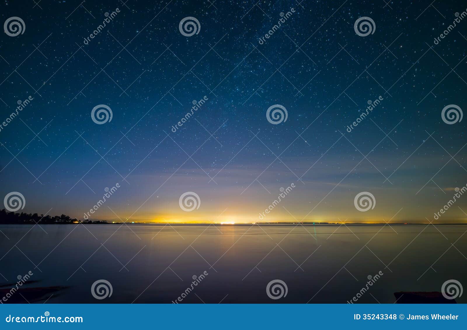 Distant City Lights with Stars and Water Stock Photo - Image of ...