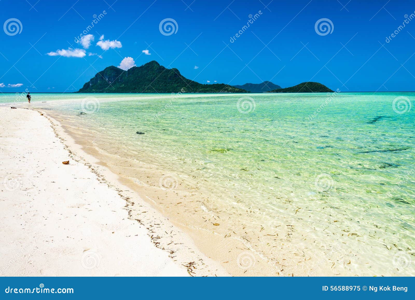 A Distant Man Strolling Along the White Sandy Beach on a Deep Blue Sky ...