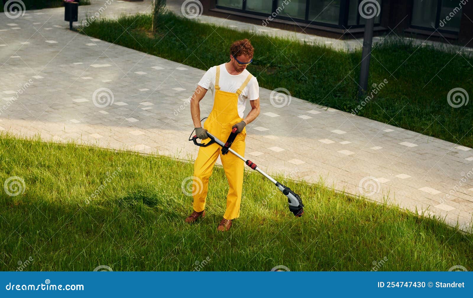 Distant View. Man Cut the Grass with Lawn Mover Outdoors in the Yard ...