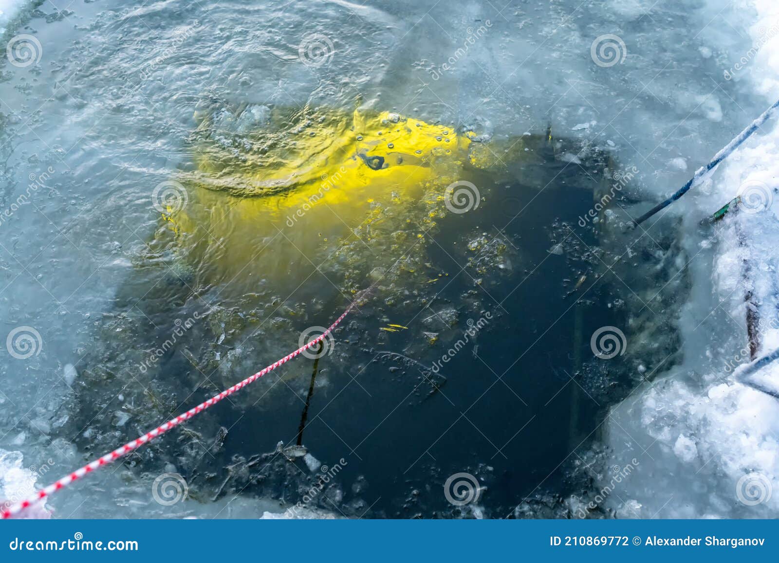 A Diver from Under the Water Shines with a Flashlight Torch an Ice Hole ...
